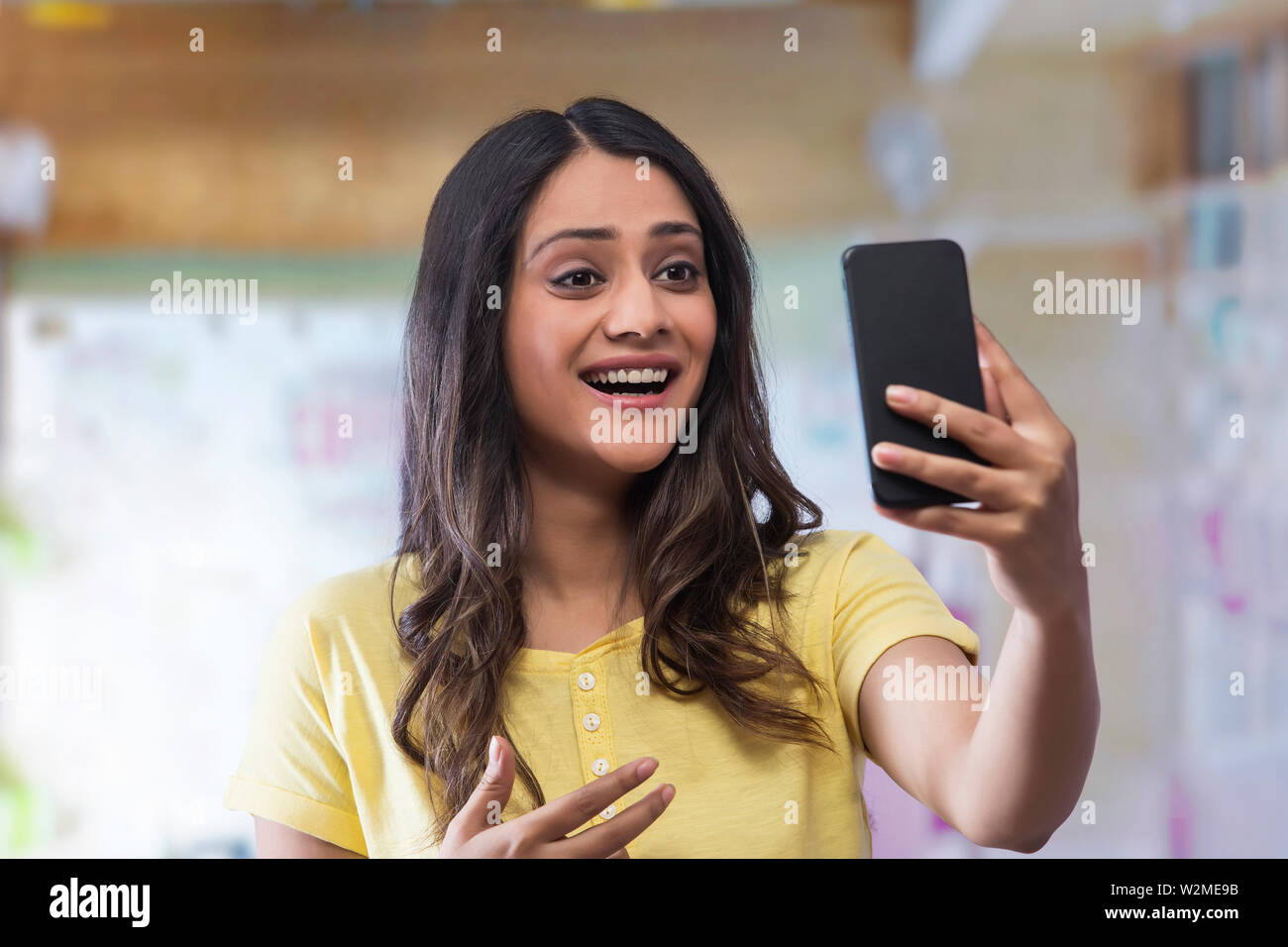 Portrait of a smiling young girl taking selfie using mobile phone Stock ...