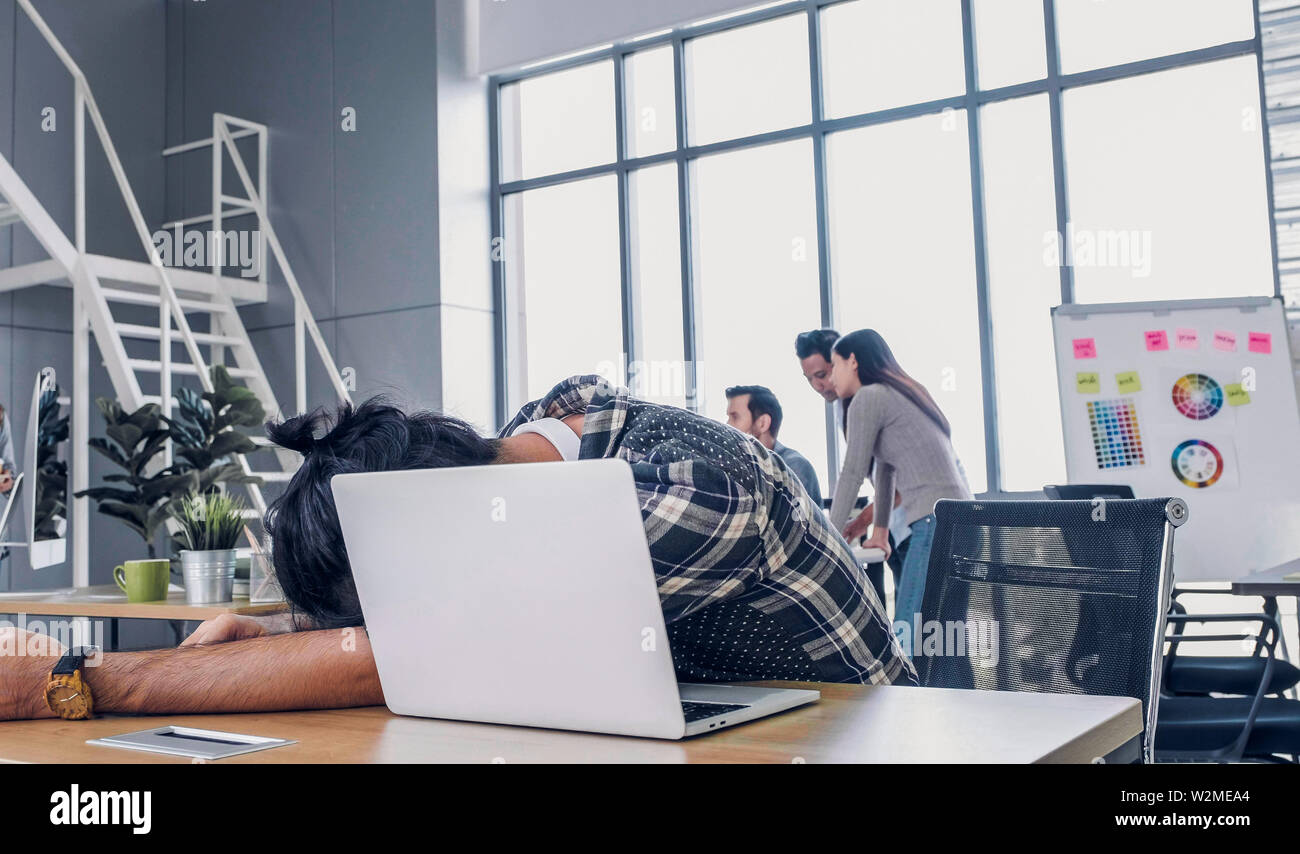 creative designer fall asleepy while working hard with laptop at modern ...
