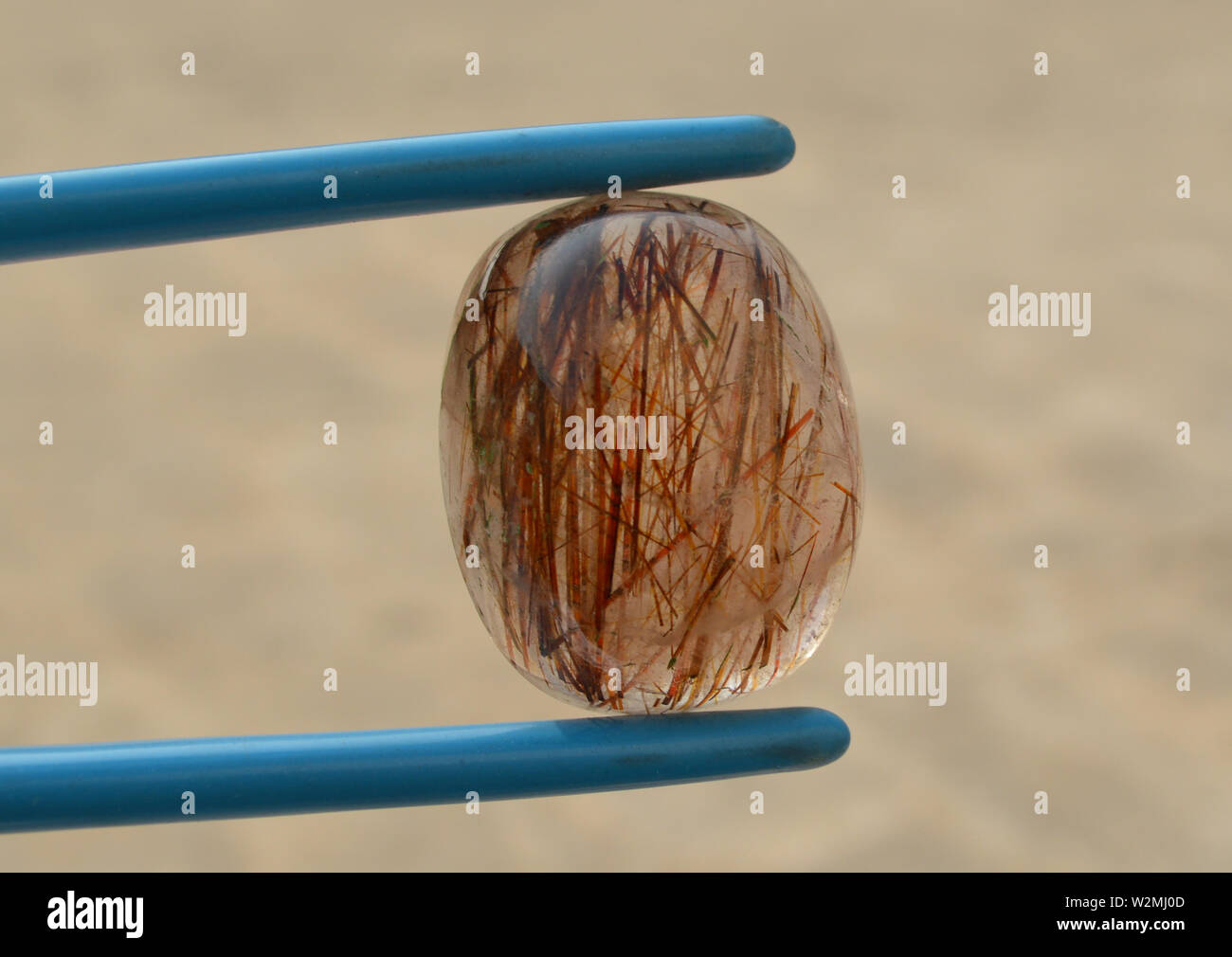 Quartz with red and golden rutile inclusion, cut and polished cabochon ...
