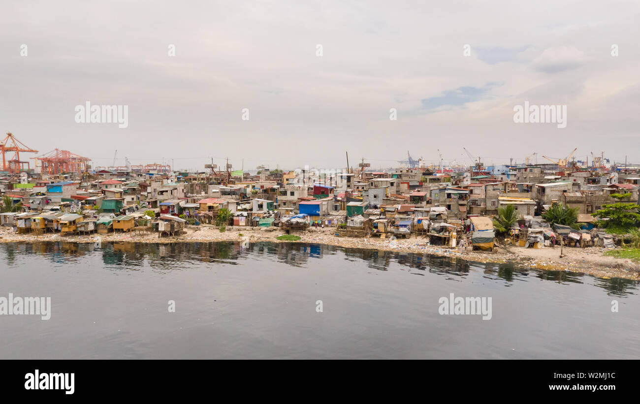 Slums in Manila near the port. Houses of poor inhabitants. A lot of ...