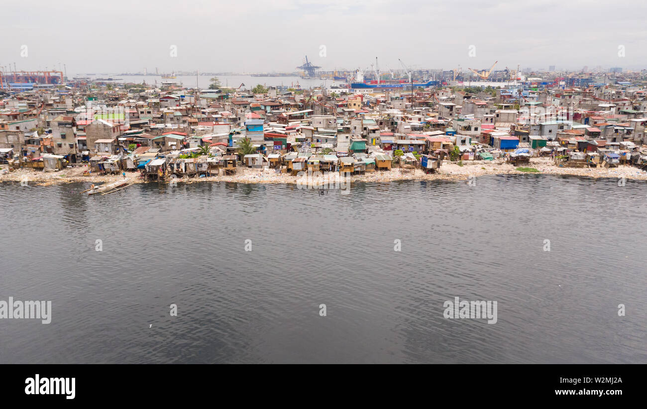 Slums in Manila near the port. Houses of poor inhabitants. A lot of ...