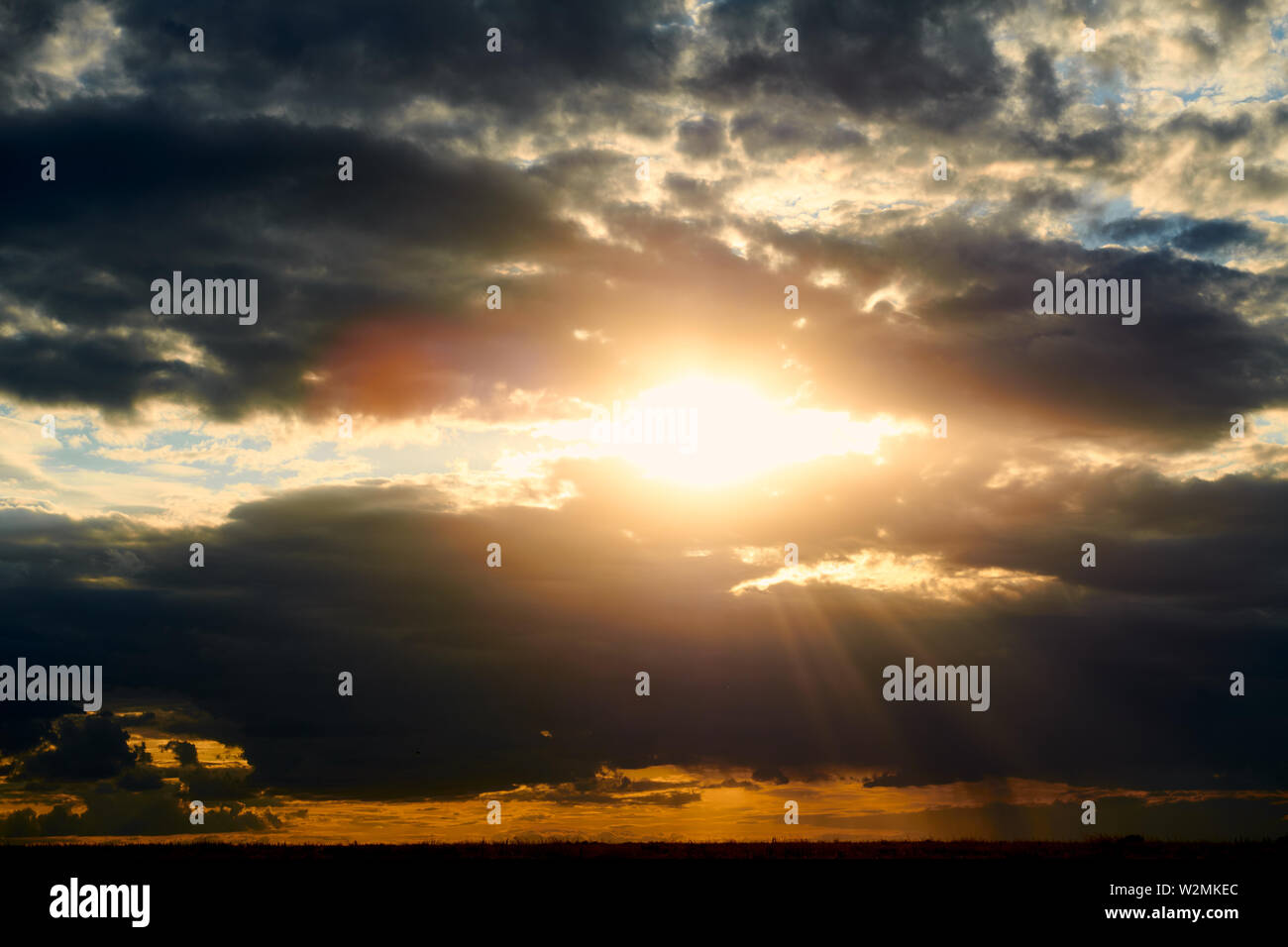 Beautiful sunset - dark sky with clouds and sunlight Stock Photo - Alamy