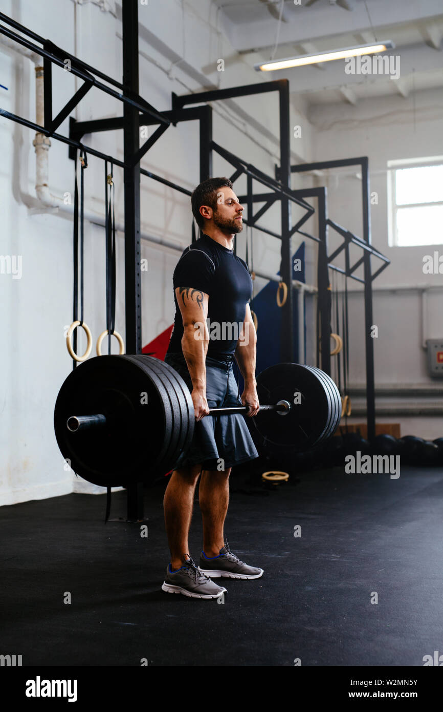 Weightlifter lifting barbells at gym. Deadlift exercise Stock Photo - Alamy