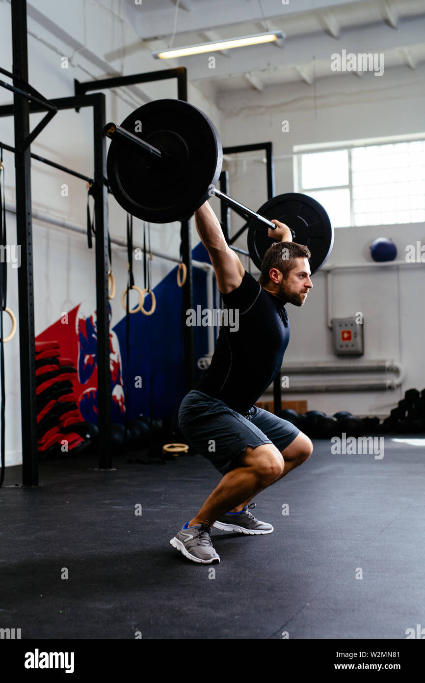 Fit man performing weightlifting exercise in gym Stock Photo - Alamy