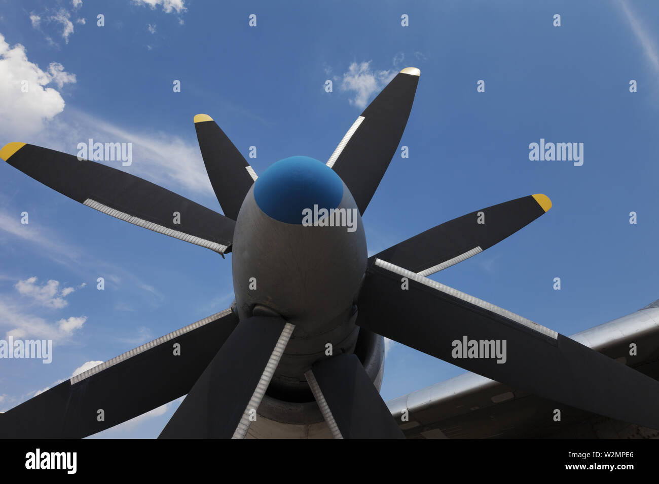 Propeller blade of engine. Part of airplane and blue sky with clouds at ...