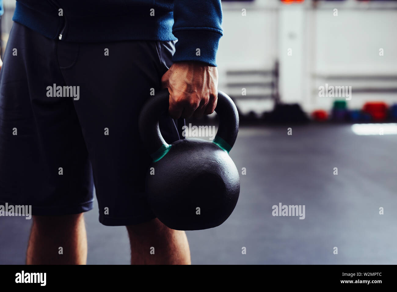 Strong man holding kettlebell Stock Photo - Alamy