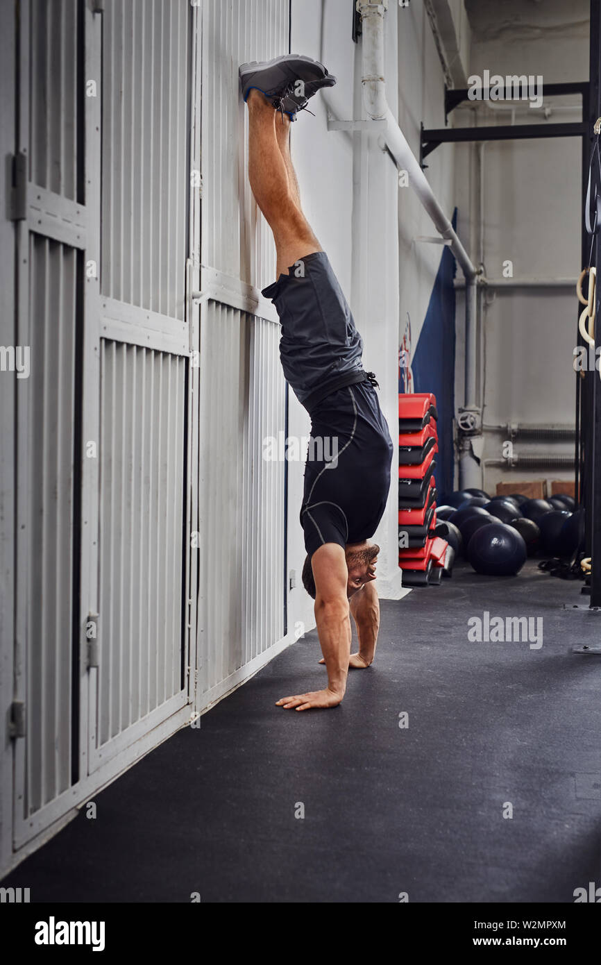 Bodyweight exercise, man standing on hands at gym Stock Photo - Alamy