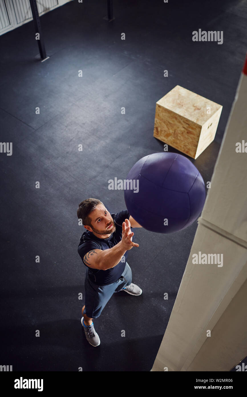 Yong athlete doing wall ball exercise at gym Stock Photo - Alamy