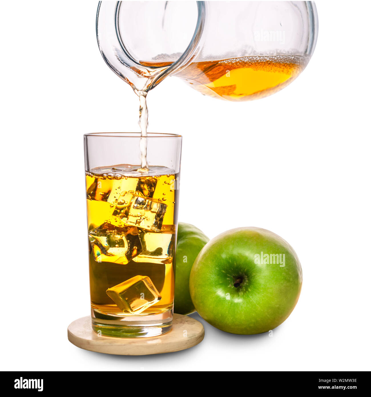 glass with ice and pouring apple juice decorated fruits on stone ...