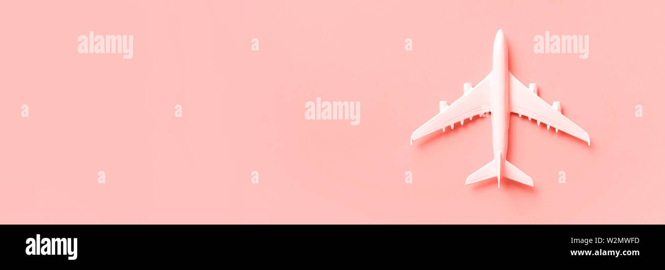 White plane, airplane on trendy coral color background with copy space ...
