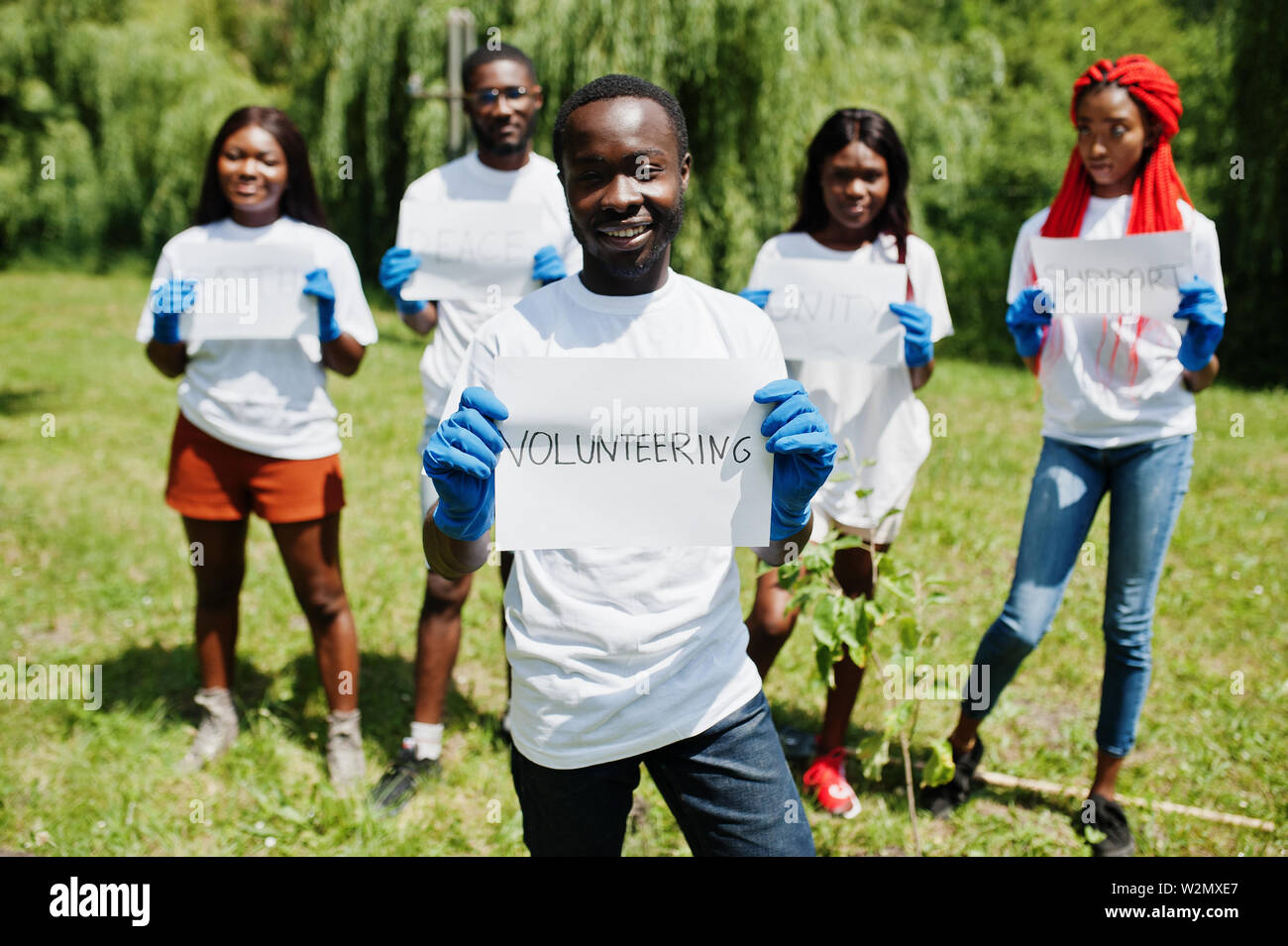 Group of happy african volunteers hold blank board with volunteering ...