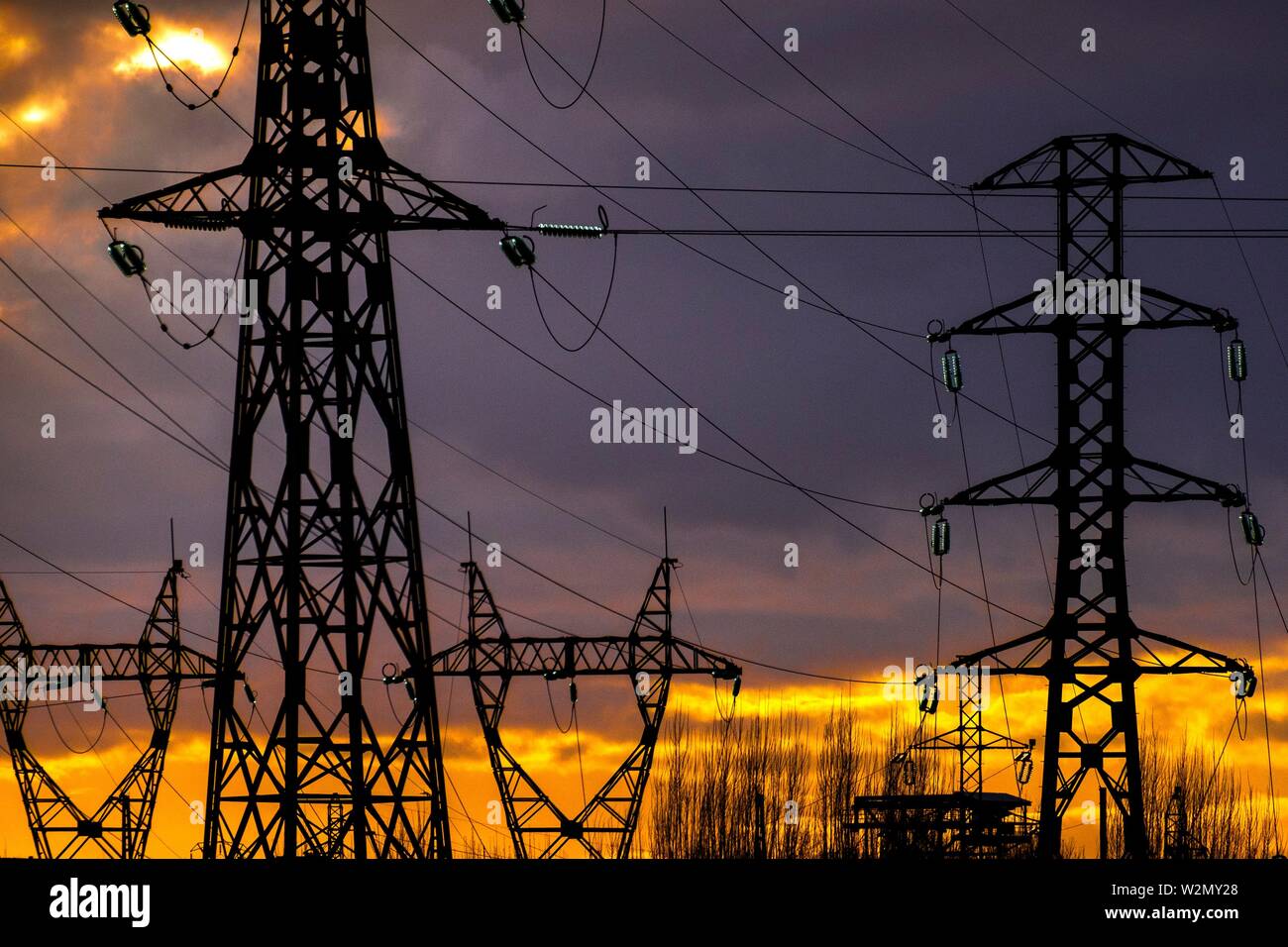 Electricity pylons at sunset Stock Photo - Alamy