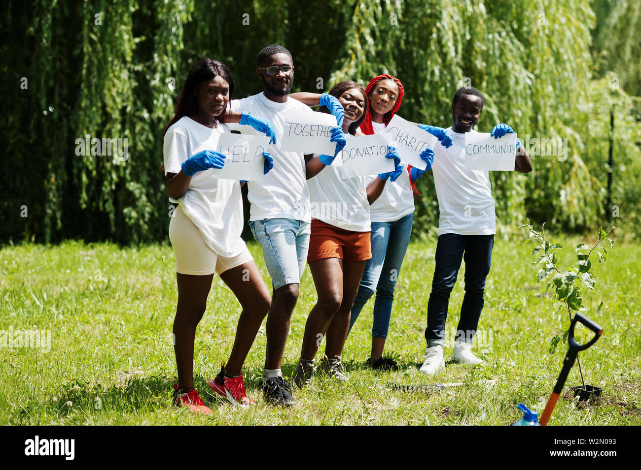Group of happy african volunteers hold blank board in park. Africa ...