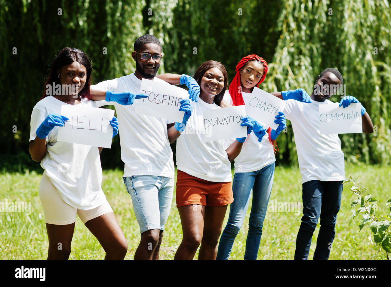 Group of happy african volunteers hold blank board in park. Africa ...