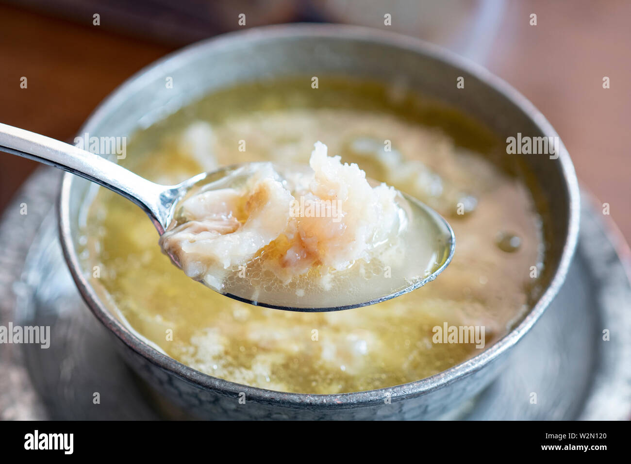 Kelle Paca soup in a bowl / plate with spoon and lemon on wooden table ...