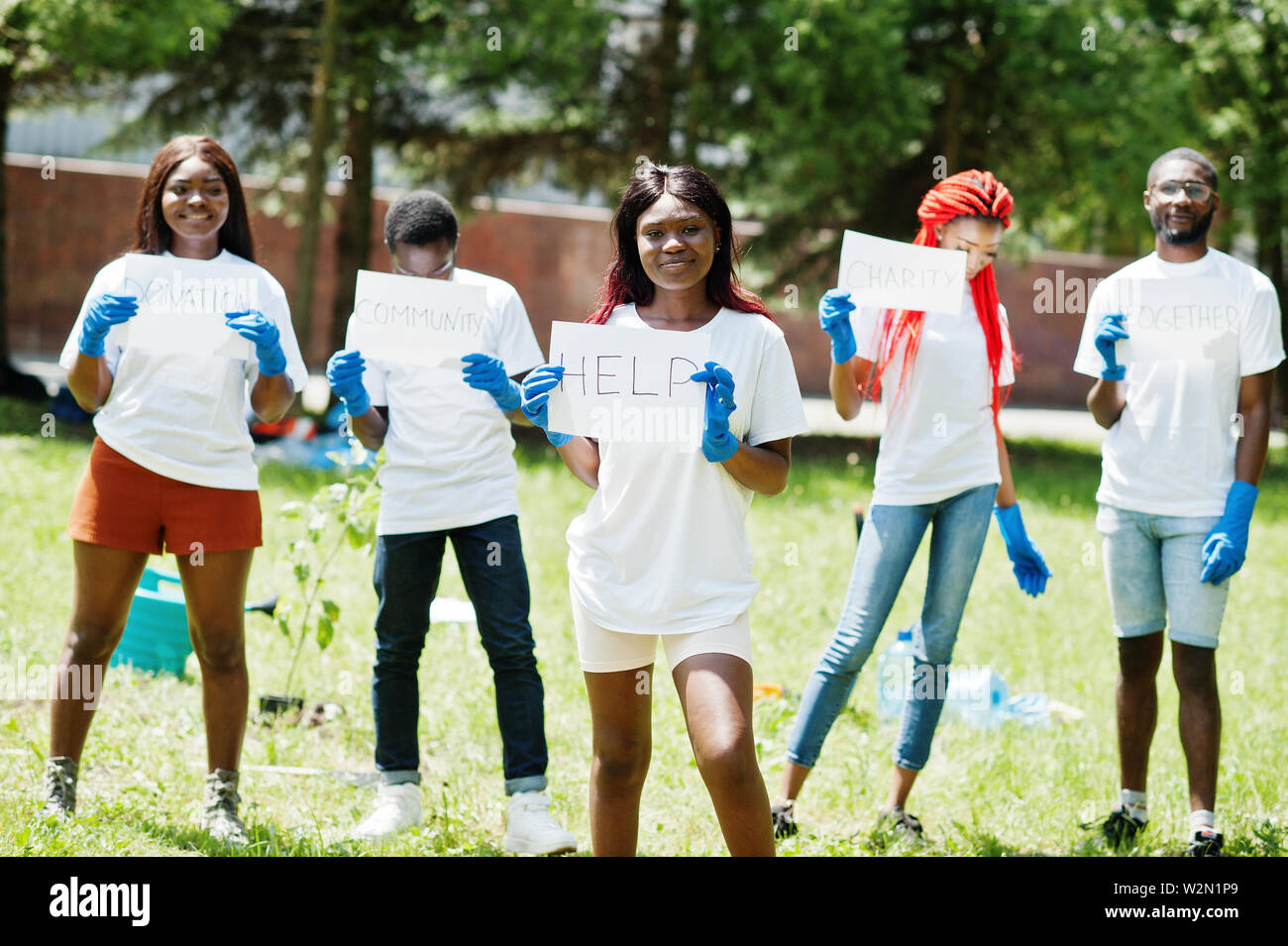 Group of happy african volunteers hold blank board with help sign in ...