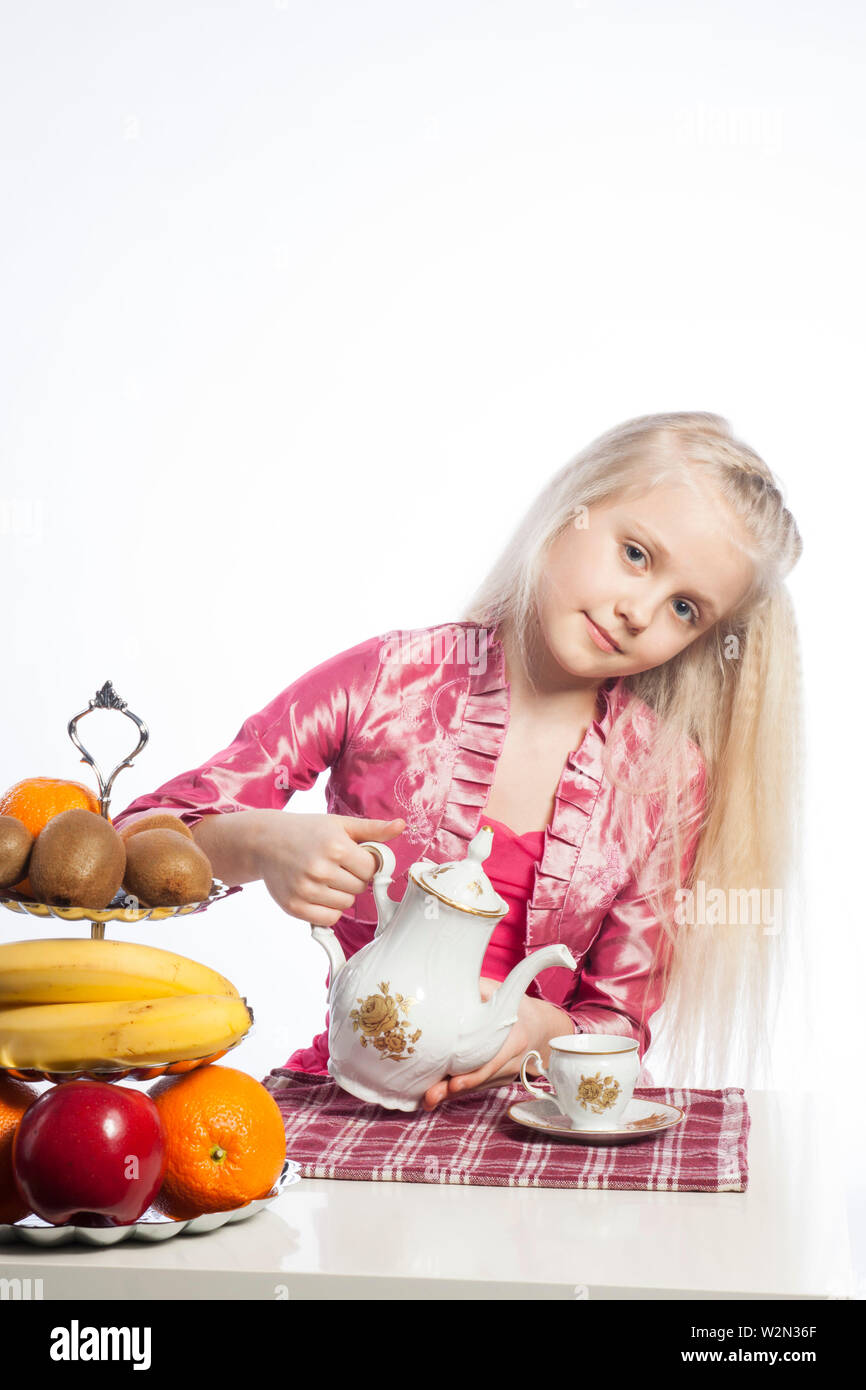 Beautiful girl pouring tea into a cup on white background Stock Photo ...