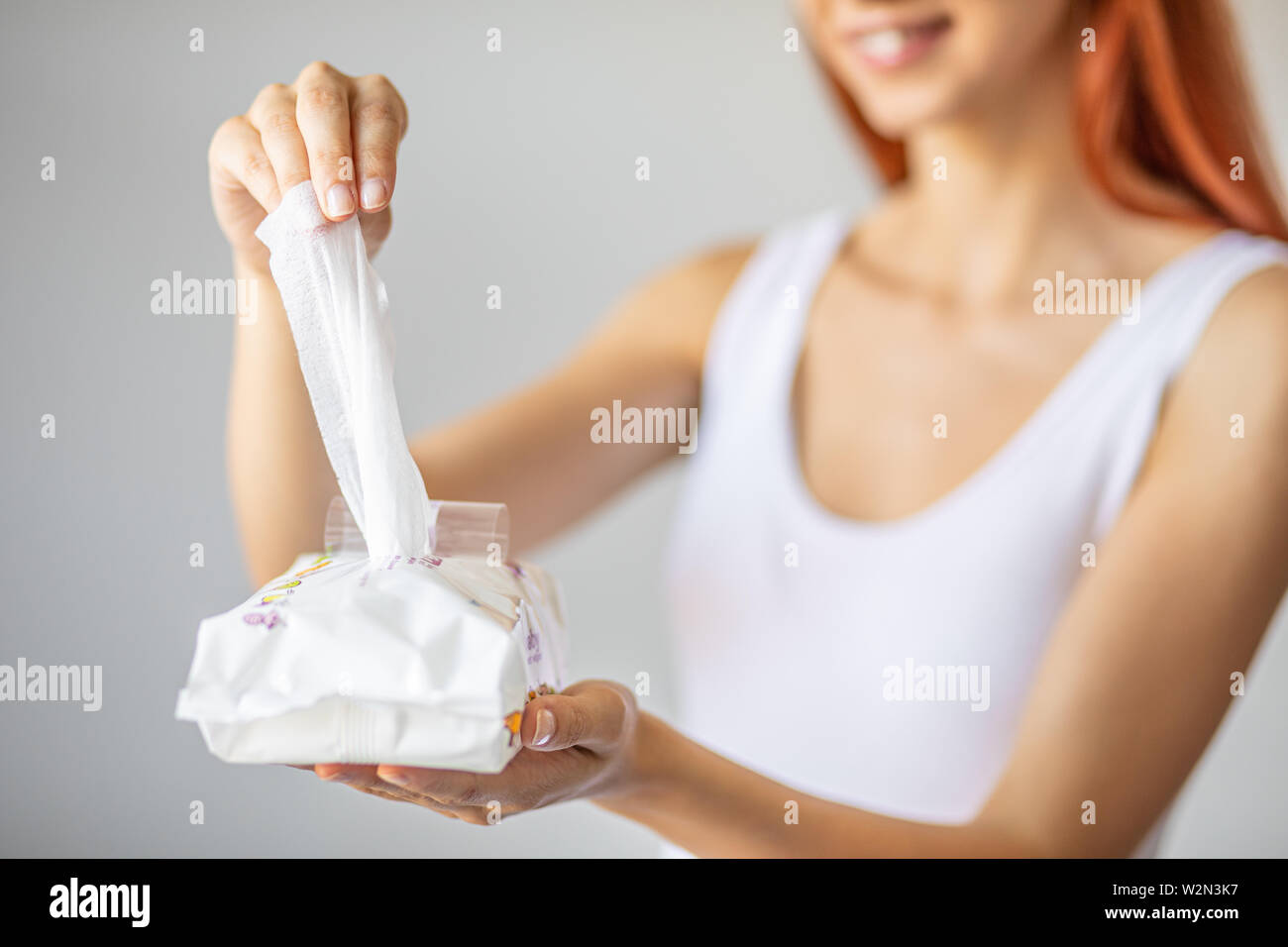 Wet wipes are universal an practical: red-hair women take one wipe from ...