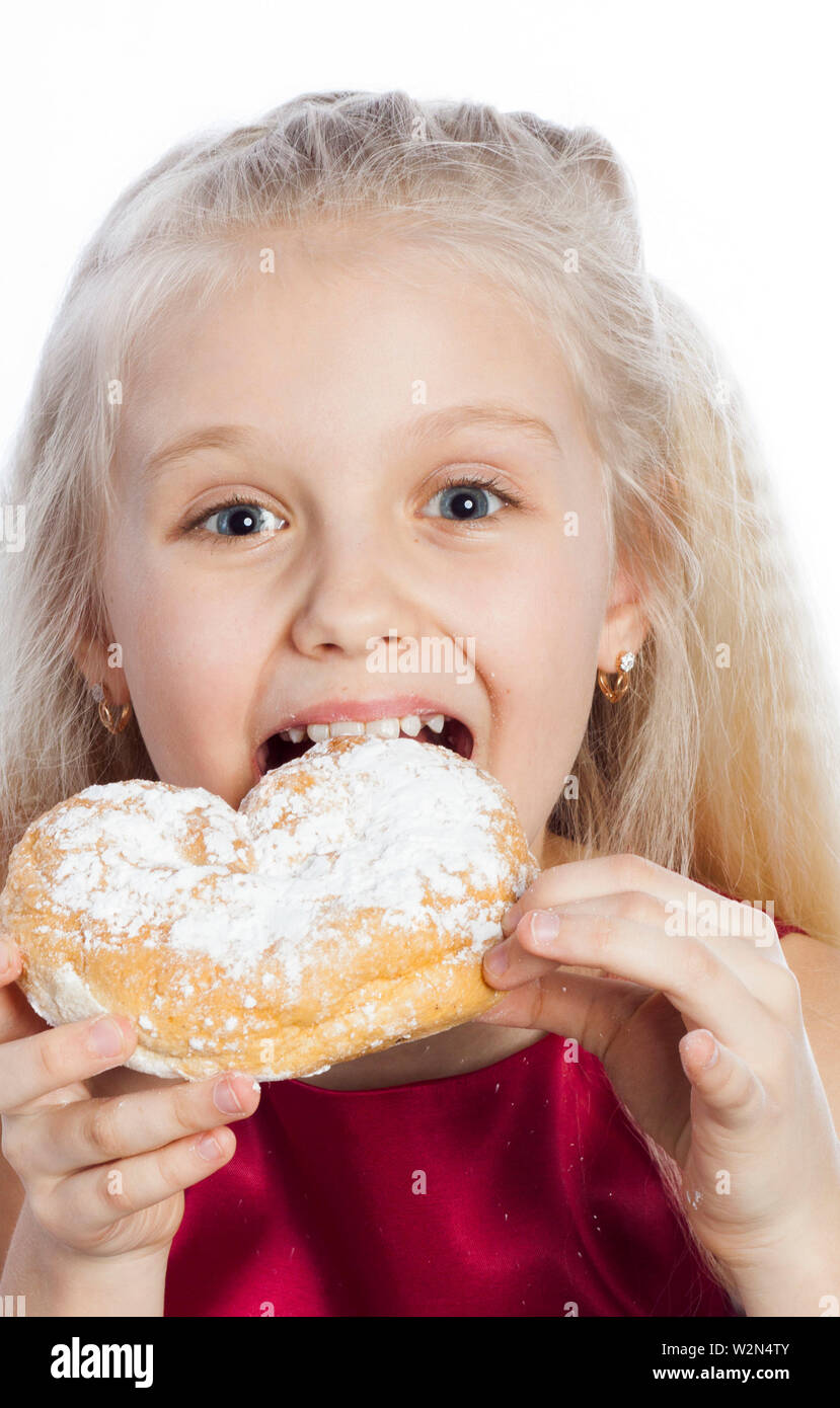 Girl biting a heart-shaped biscuit on white background Stock Photo - Alamy