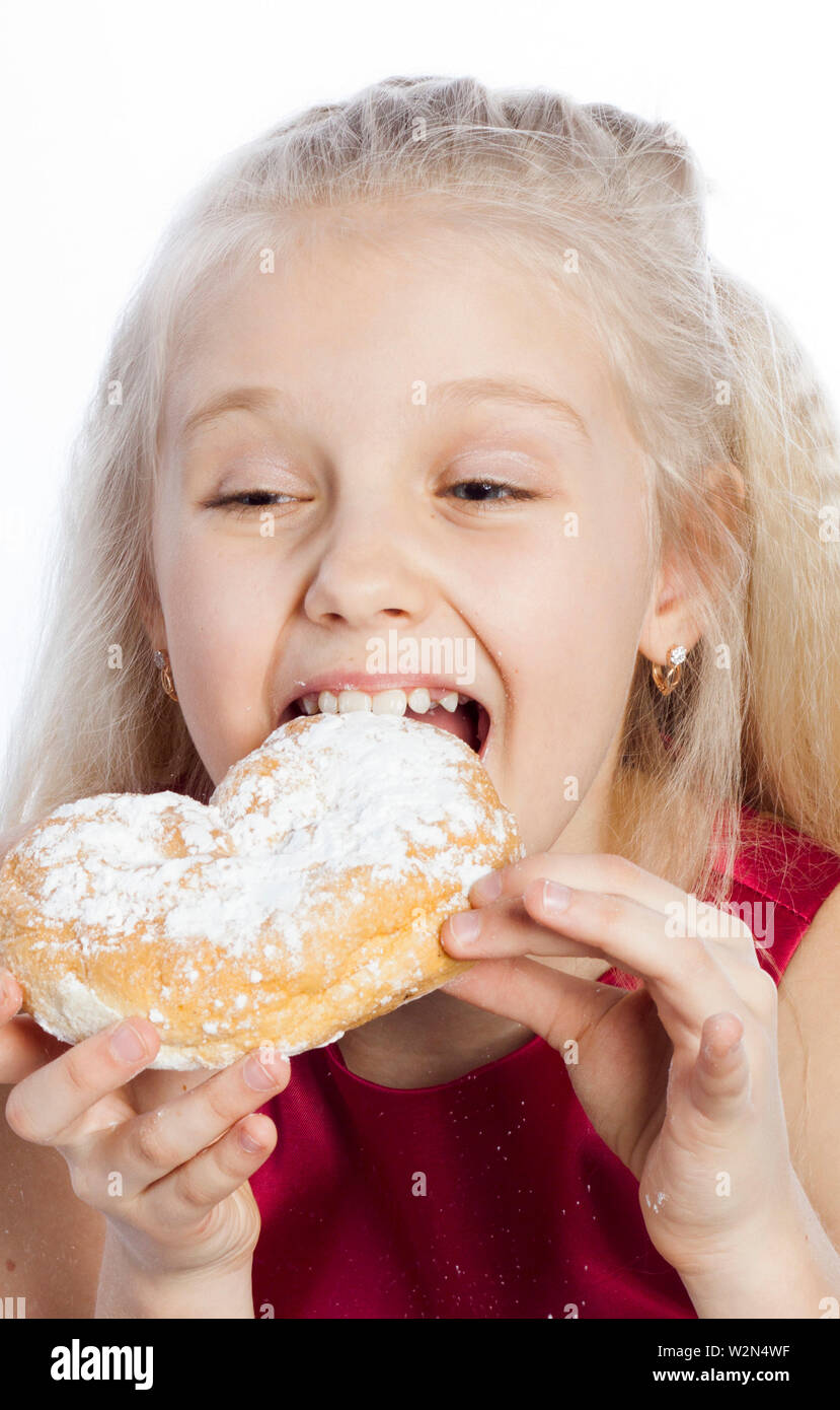 Girl biting a heart-shaped biscuit on white background Stock Photo - Alamy