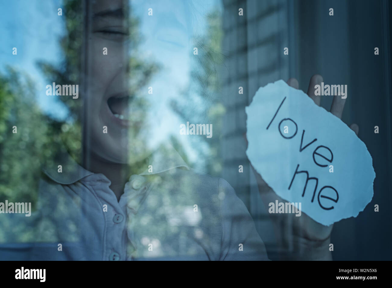 girl crying at the window with a note in his hand Stock Photo - Alamy