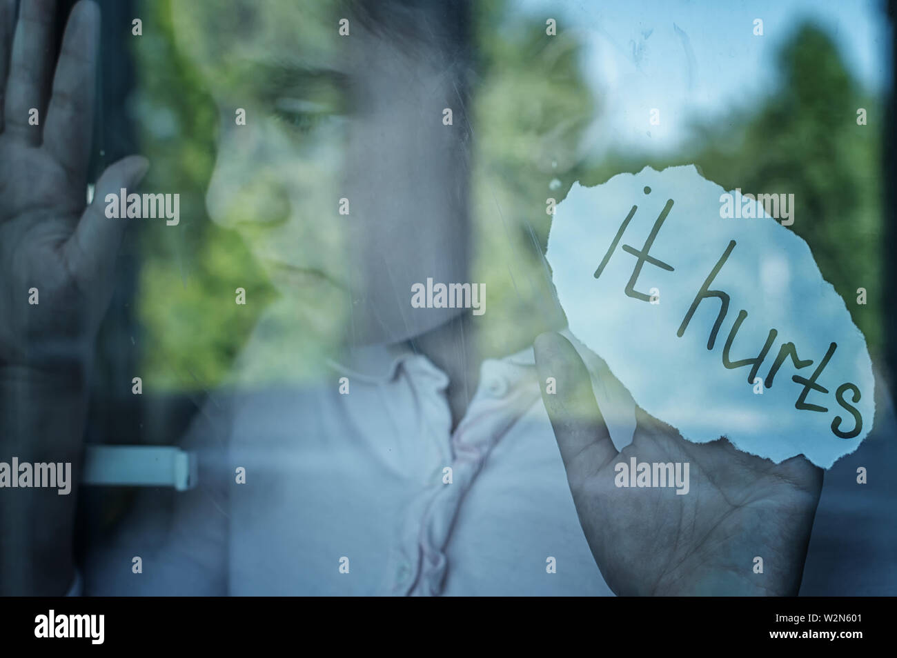 girl crying at the window with a note in his hand Stock Photo - Alamy