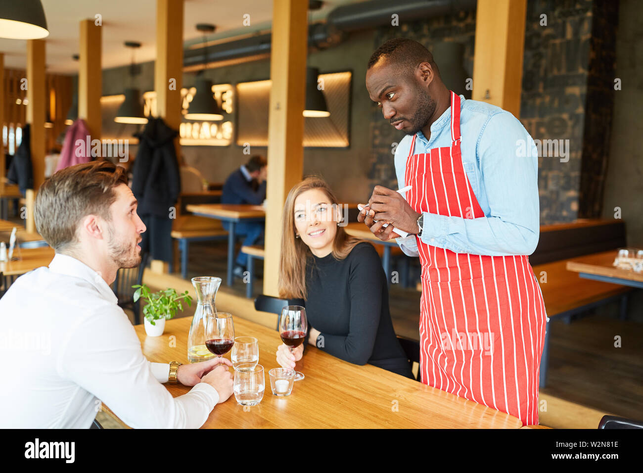 African man as a waiter takes the guests order in the restaurant Stock ...