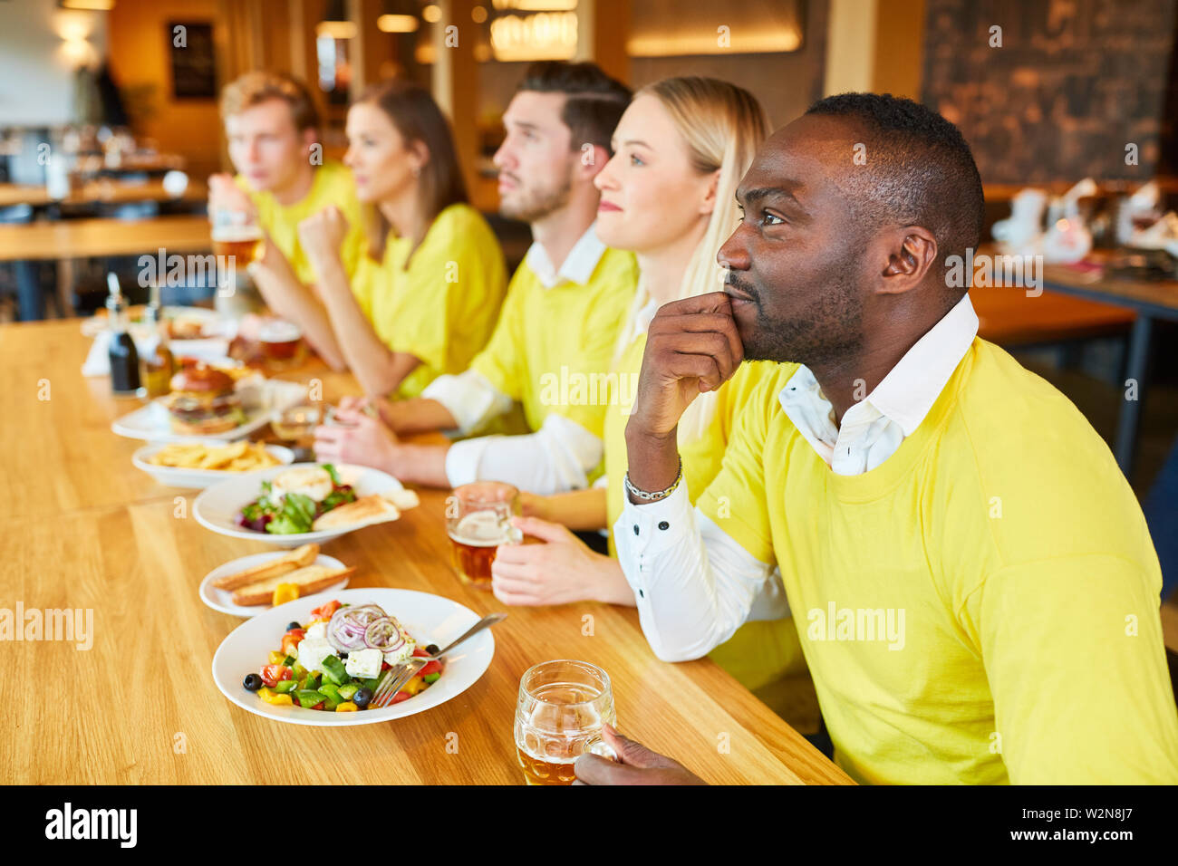 Fans watch a team play during public viewing in a pub or bar Stock ...