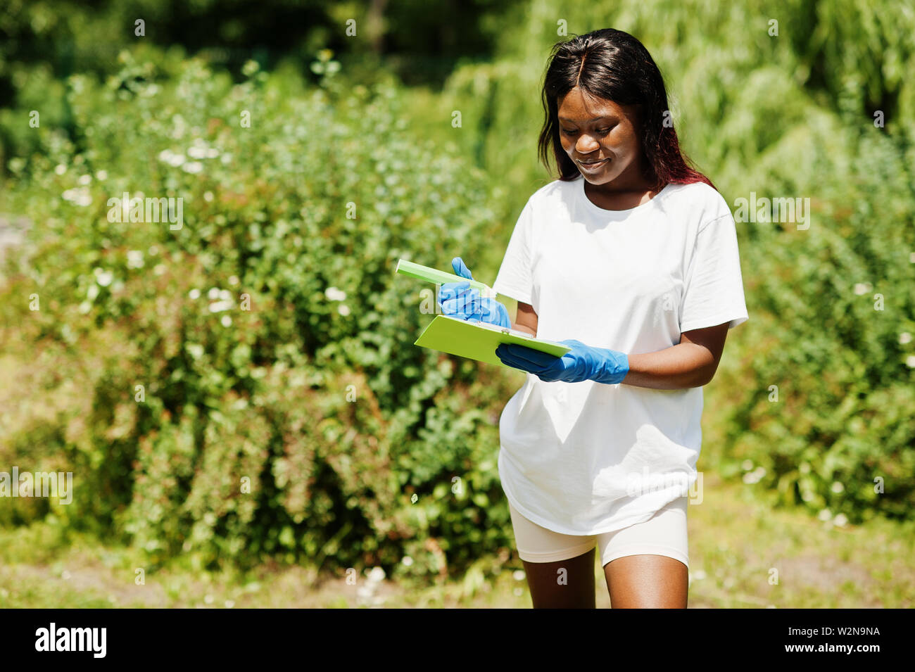 African volunteer woman with clipboard in park. Africa volunteering ...