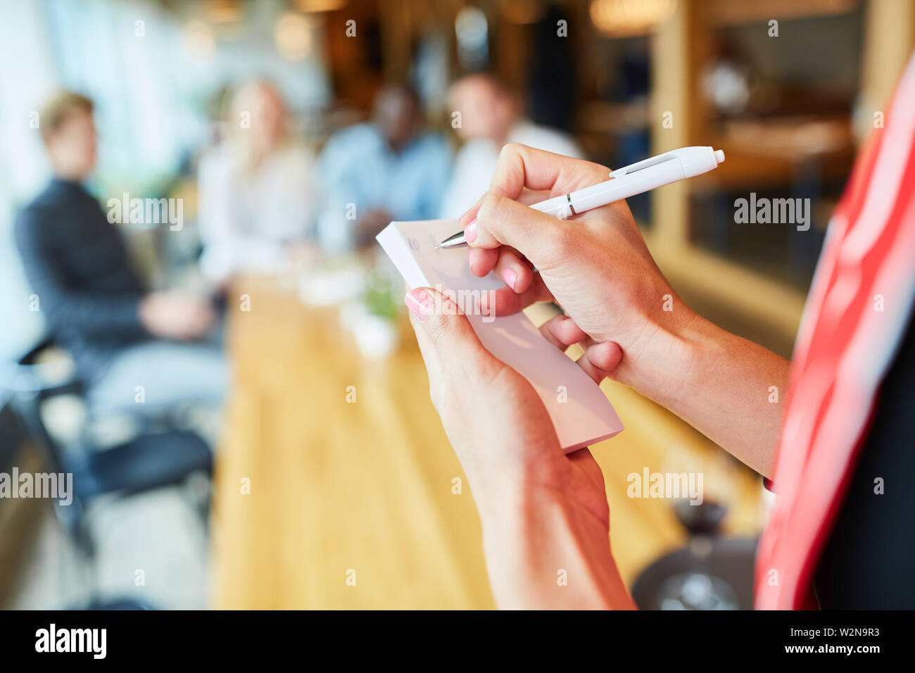Waiter or waitress with notepad takes an order in the restaurant Stock ...