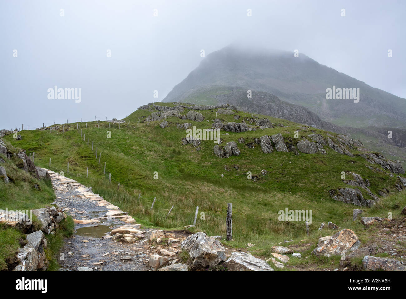 PYG track hiking route up to foggy Snowdon mountain summit on overcast ...