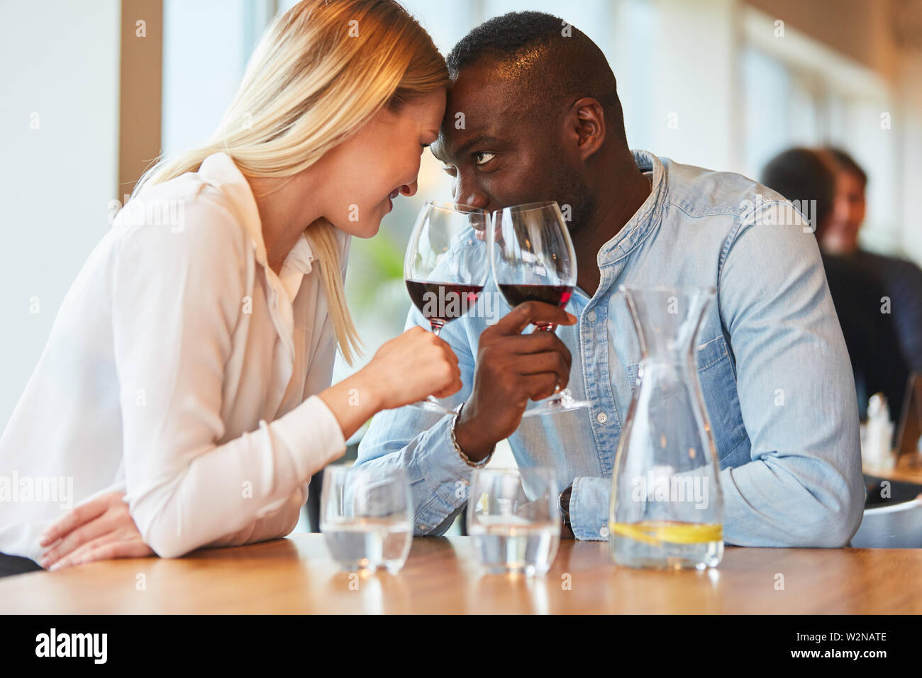 Multicultural young couple in love having wine in restaurant Stock ...