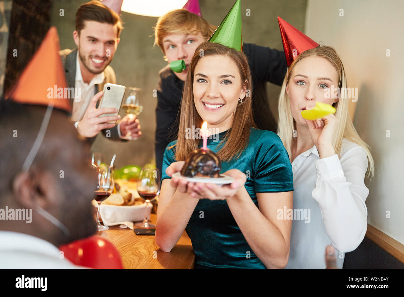 Friends at a party celebrate their birthday and are photographed with ...