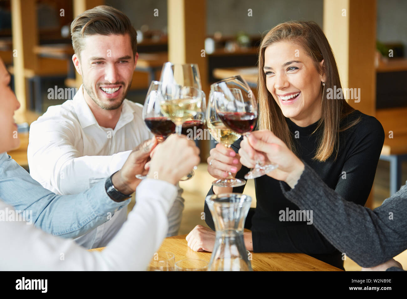 Young people toast with glass of wine in the restaurant and celebrate ...