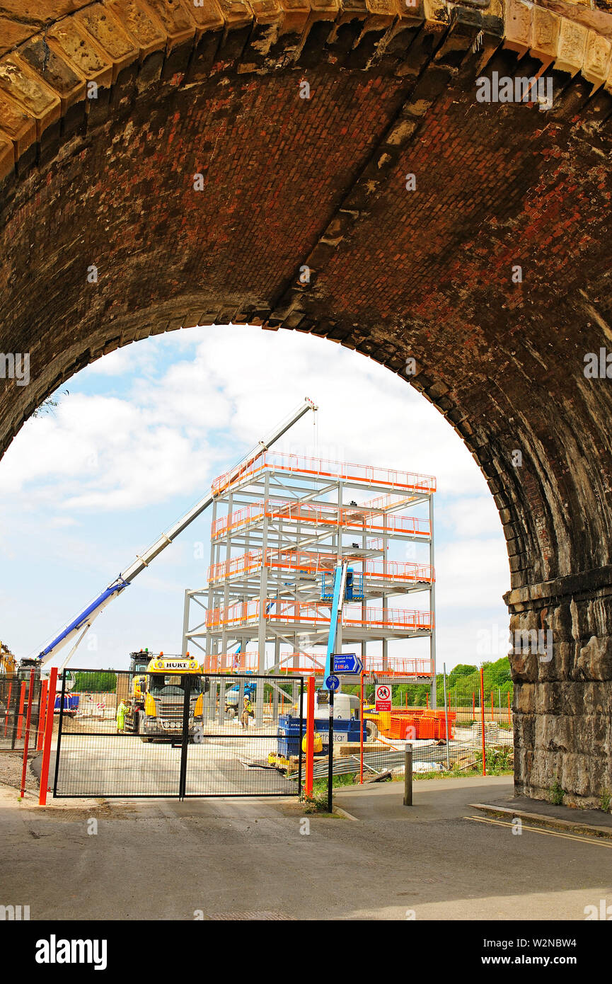Construction work seen through the archway of an old Victorian bridge ...