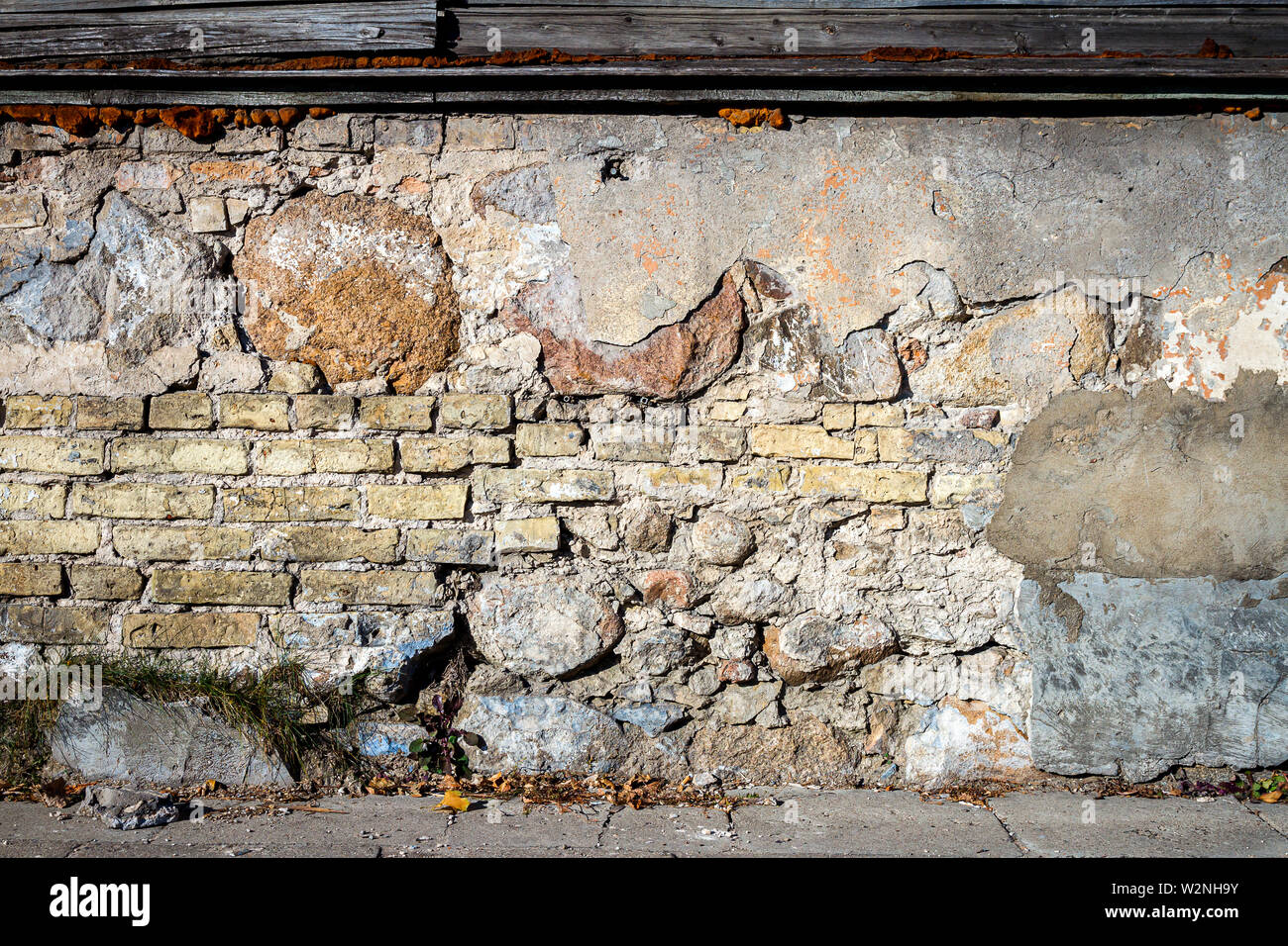 Old gray cracked plaster and brick wall. Abandoned exterior urban ...