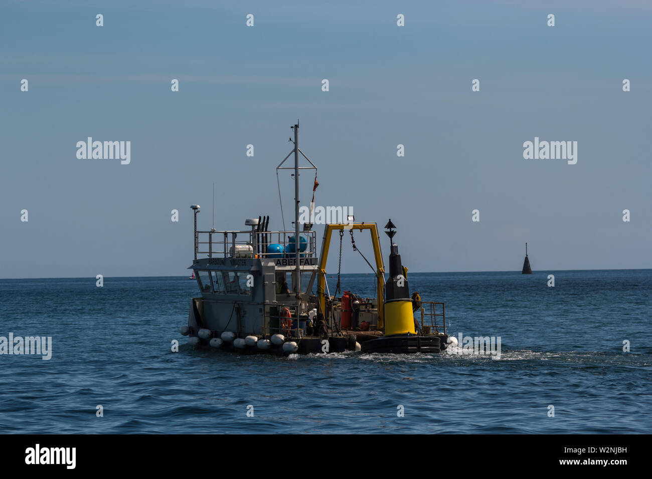 Boat towing a cardinal buoy Stock Photo - Alamy