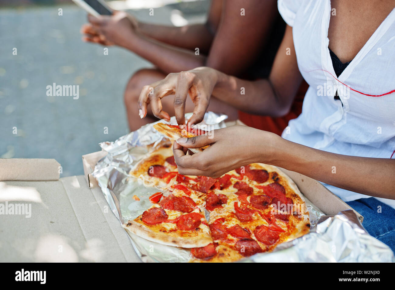 Hands of african american woman with pizza Stock Photo - Alamy