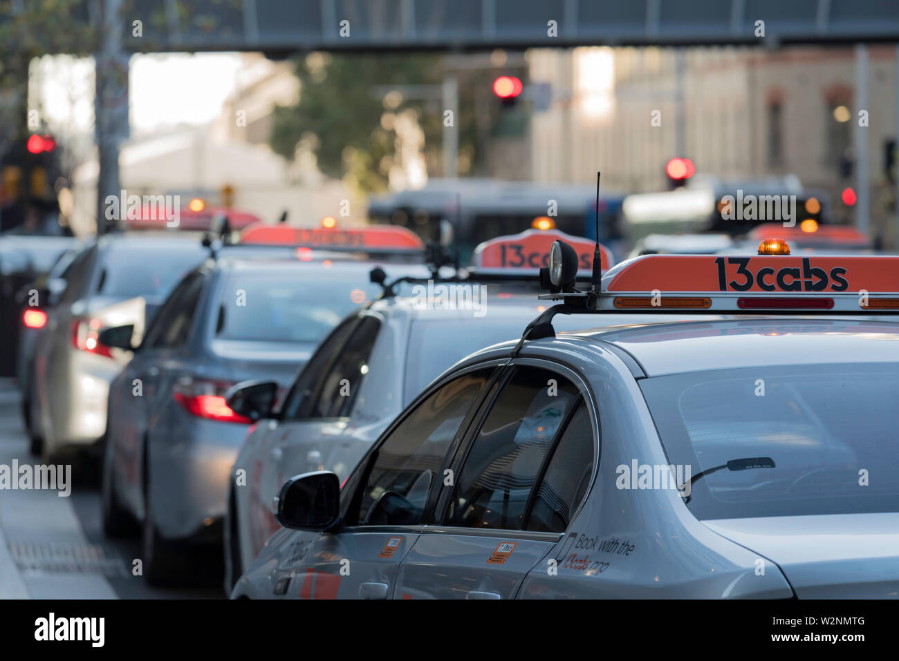 A line of taxis wait with their light on outside a building in Sydney ...