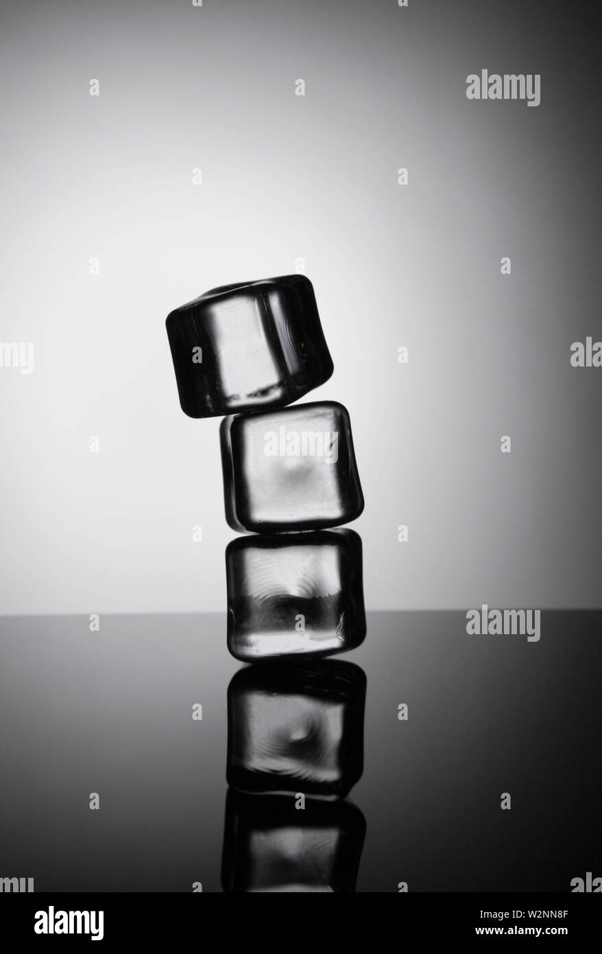 Three ice cubes with water on mirror background Stock Photo - Alamy