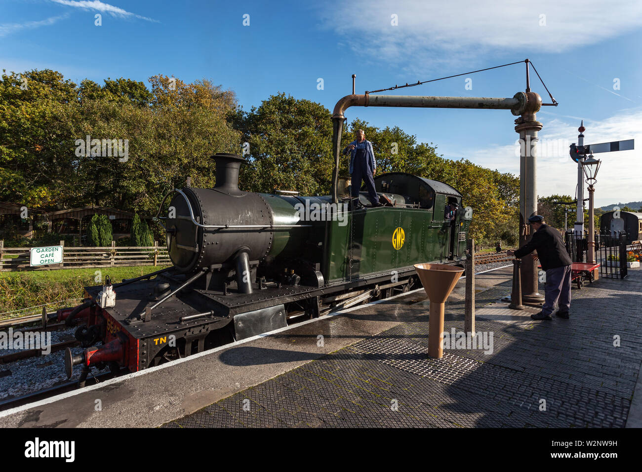 A steam engine refilling water in station Stock Photo - Alamy
