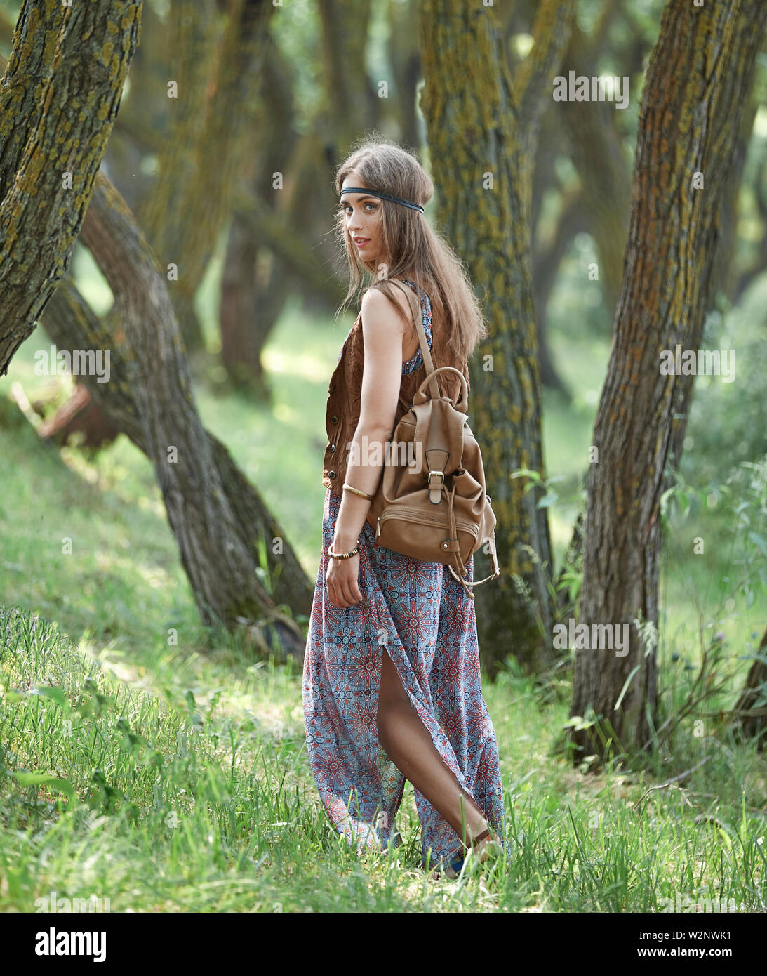 attractive hippie girl walking through the forest . the concept of ...