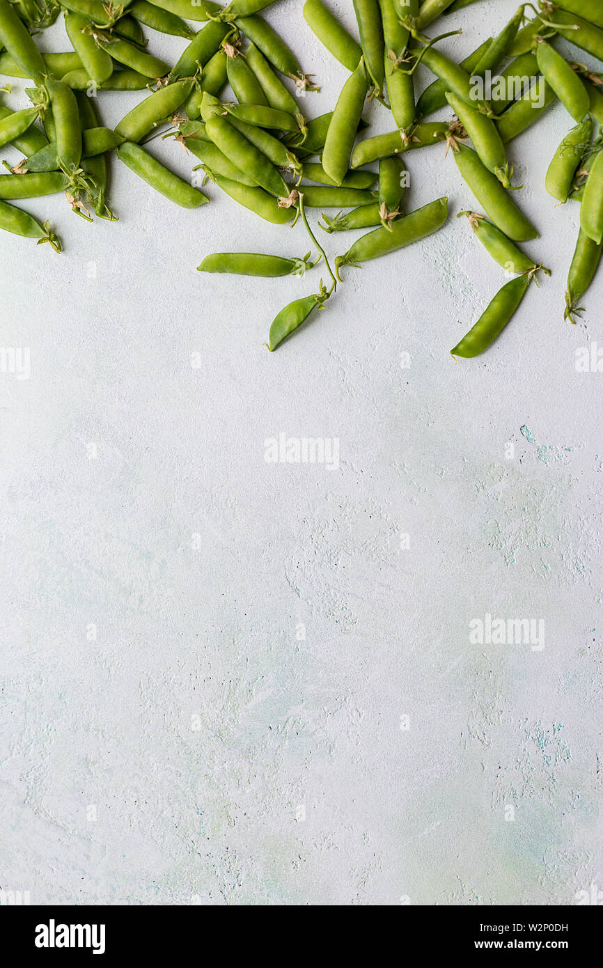 Copy space background with raw green pea, light concrete backdrop ...