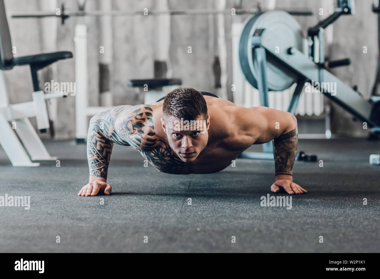 cool bodybuilder performing plank in the gym. photo with copy space ...