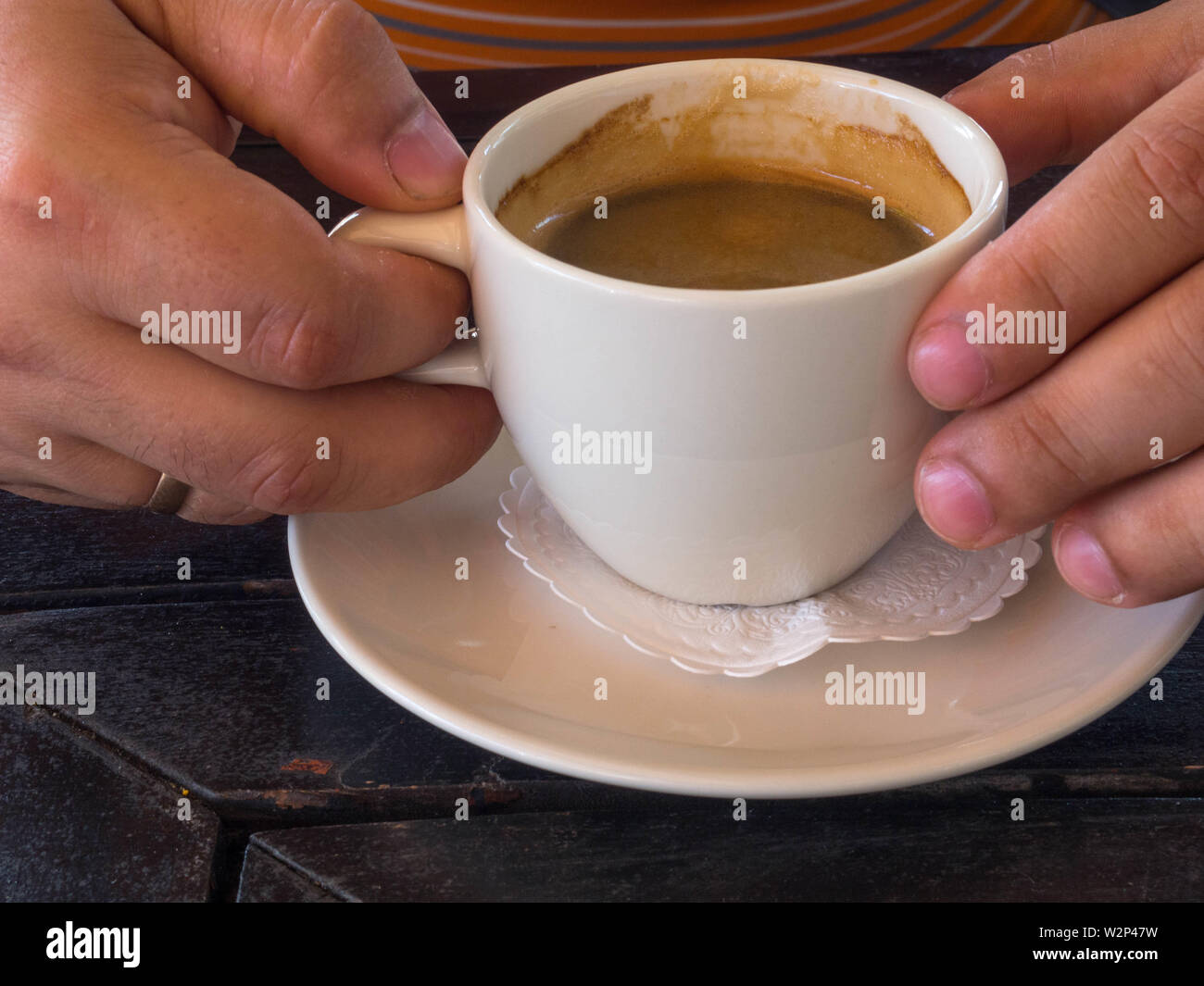Man holding in hand a cup of coffee on a wooden, vintage background ...