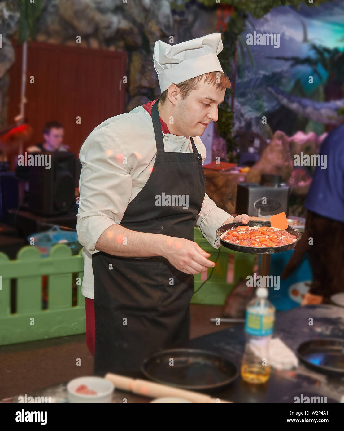 chef laying out slices of tomatoes on pizza. master class Stock Photo ...