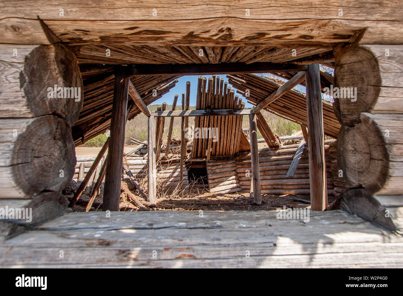 View through a window into an old wooden yurt. Frame from the window ...