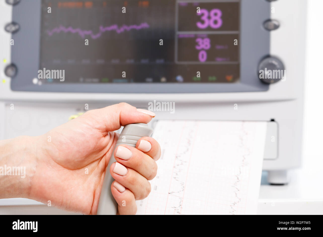 Close-up shot of pregnant woman's hand holding controller of the ...