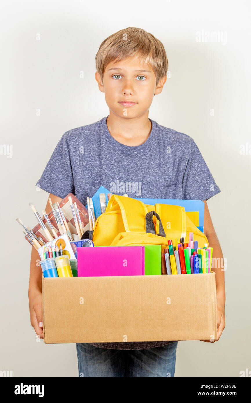 Donation concept. Kid holding donate box with books, pencils and school ...