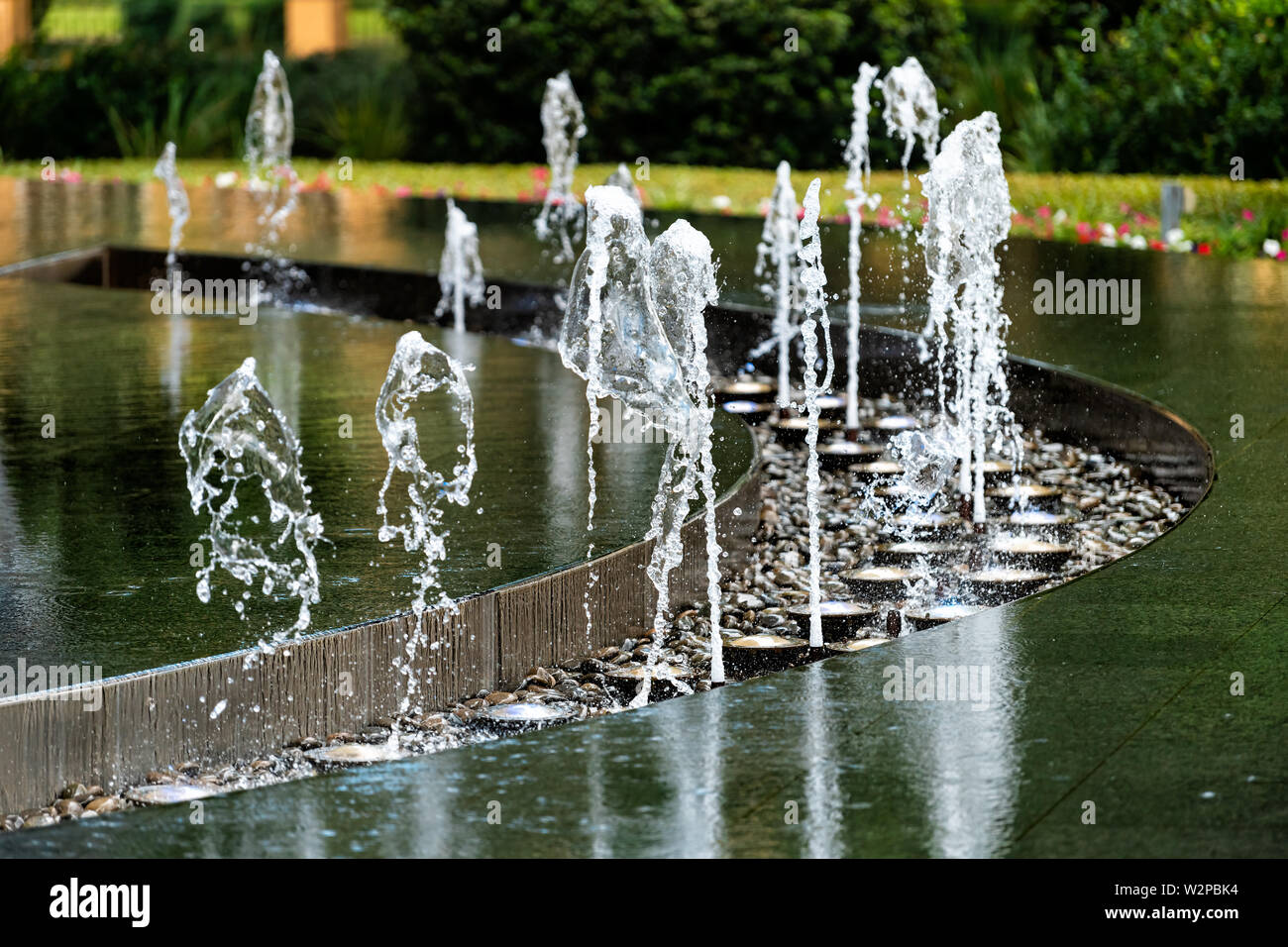 Abstract modern water fountain closeup with reflection in urban hotel ...